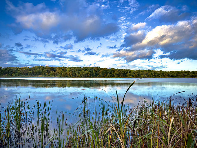 Dawn breaks over Busse Lake, painting the sky in watercolor hues that reflect perfectly on the glass-like surface.