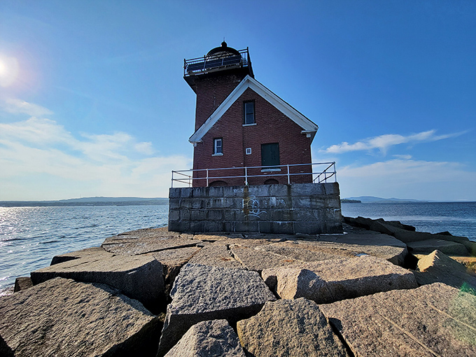 The lighthouse sits majestically on its granite foundation, where waves crash against the breakwater during high tides and storms.