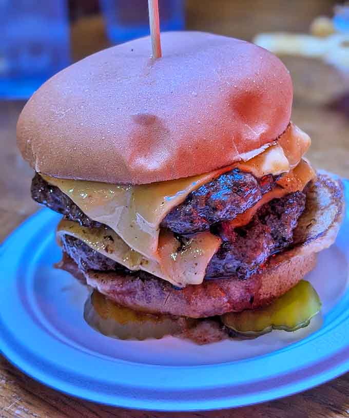 Behold the burger in its natural habitat, perfectly constructed with melted cheese cascading over a juicy patty that knows exactly what it's supposed to be.