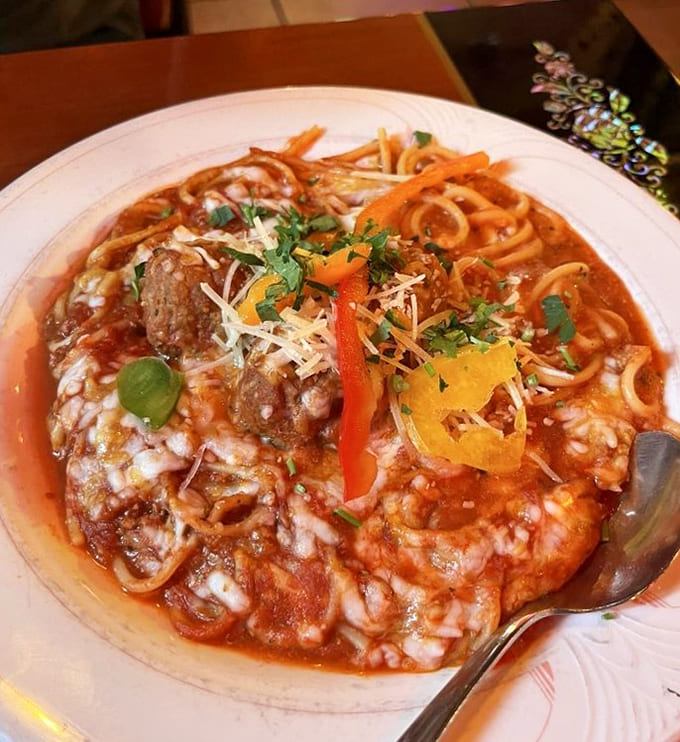 Bolognese with meatballs baked under melted cheese is basically a warm blanket for your soul, served on a plate with a fork.