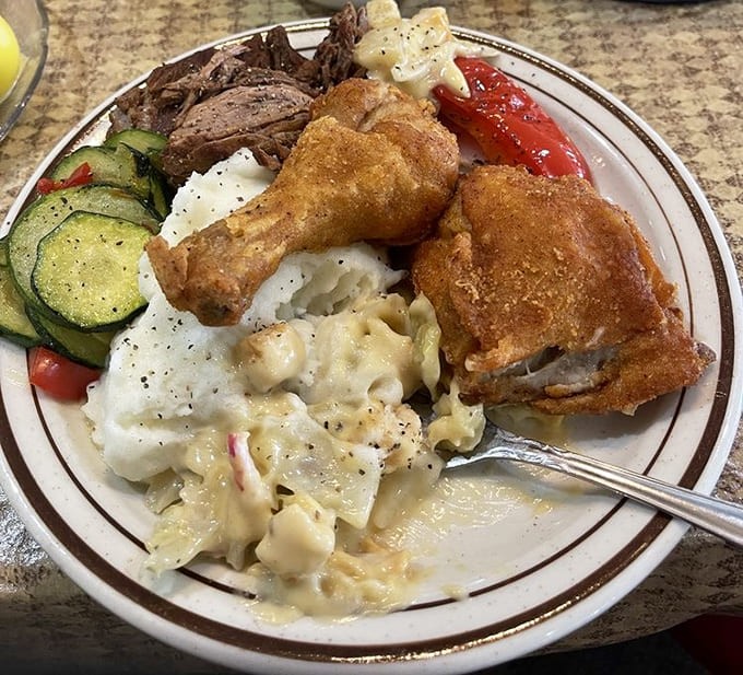 Golden fried chicken, creamy sides, and fresh vegetables come together in a symphony of comfort food perfection here.