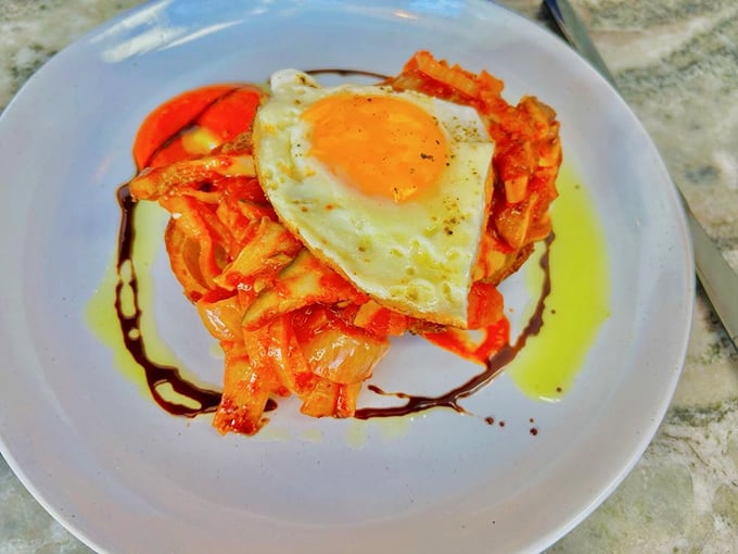 A sunny egg crowns this savory masterpiece where mushrooms and tomatoes create a bubbling bed of breakfast bliss.