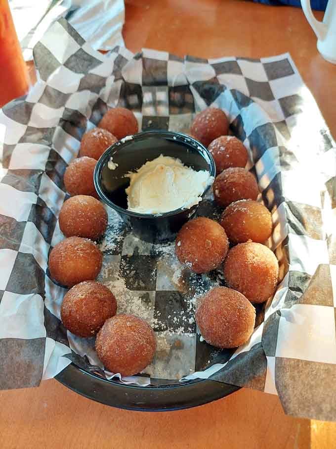 These golden donut holes arrive like tiny spheres of fried happiness, perfect for sharing or not sharing, your call.