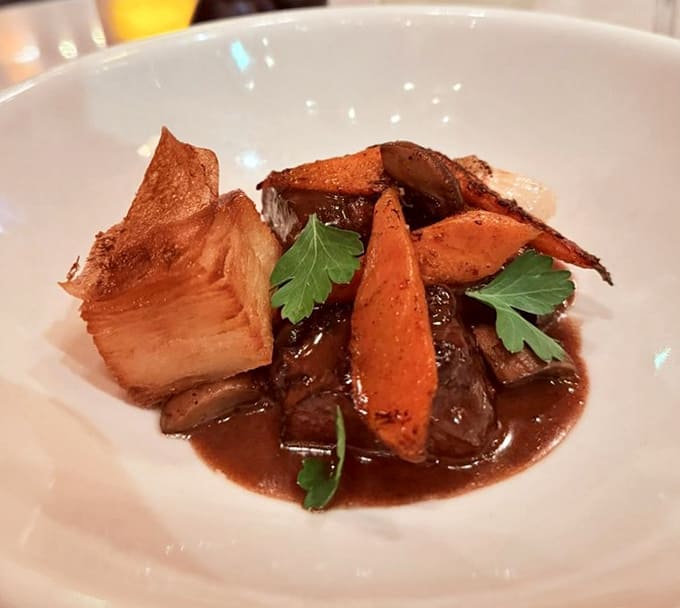 Beef bourguignon served in a way that would make Julia Child nod approvingly, rich and hearty like a warm hug in bowl form.