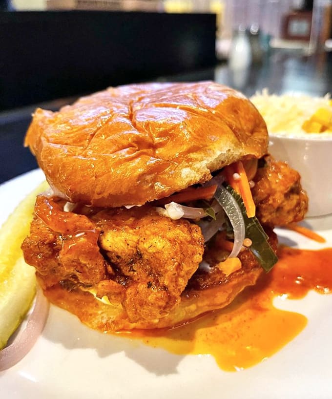 The Tennessee chicken sandwich arrives stacked high, a towering testament to the philosophy that more is definitely more when done right.