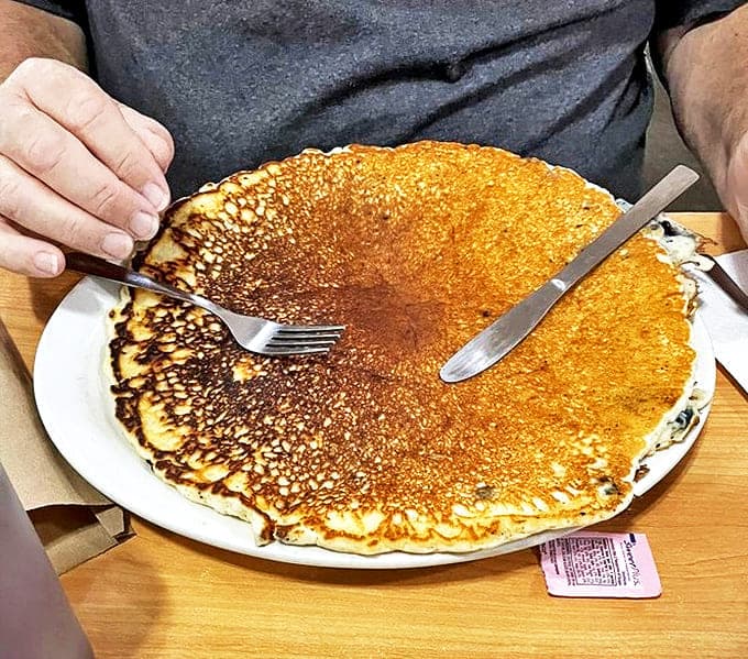This pancake isn't just breakfast &ndash; it's a commitment. Golden-brown, plate-eclipsing, and fluffy enough to use as a pillow in emergencies.