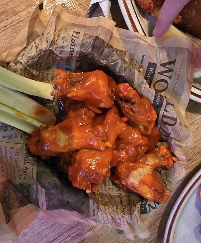 Buffalo wings glazed to perfection, served with celery sticks for the illusion of eating something healthy between bites.