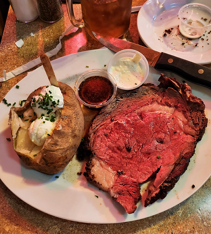 Behold the star attraction &ndash; prime rib cooked to rosy perfection alongside a baked potato crowned with a cloud of sour cream.