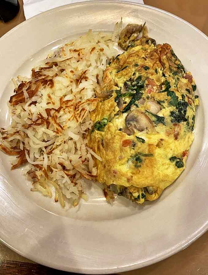 Spartan Omelet: This isn't just an omelet; it's a fluffy egg envelope delivering a love letter of spinach, mushrooms and cheese alongside crispy hash browns.