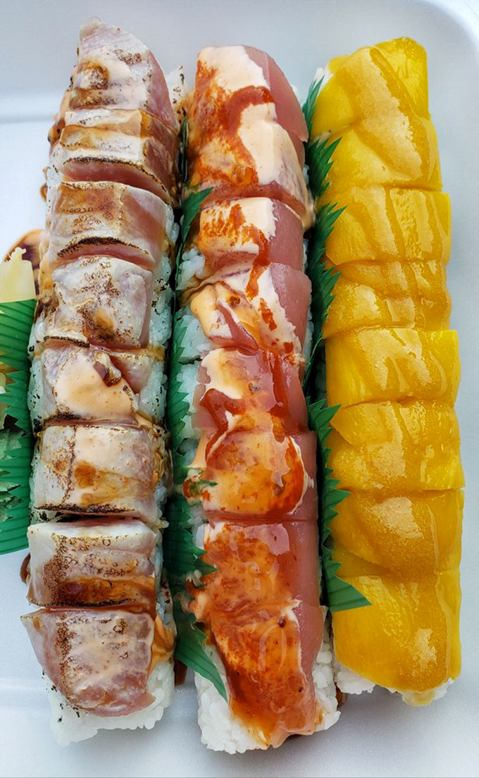 Three distinct rolls showcase the chef's artistry, from delicate yellowtail to vibrant tuna, each one a colorful masterpiece on the plate.