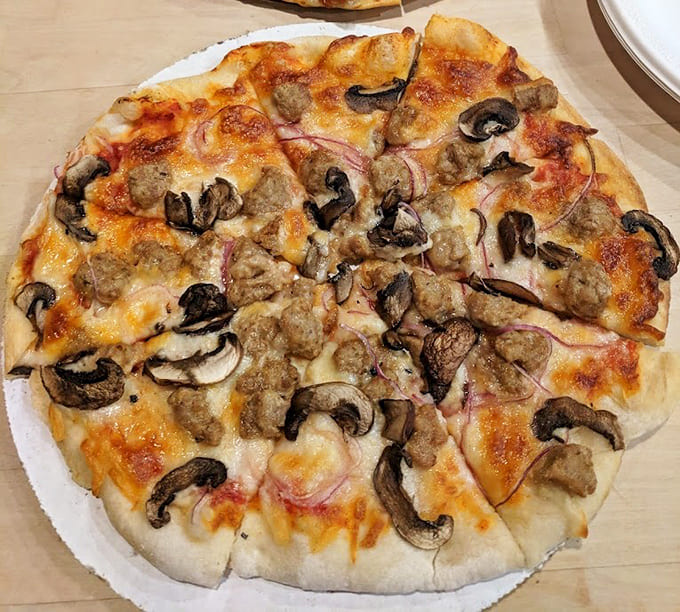 This deluxe pizza loaded with sausage, mushrooms, and onions is what happens when you don't hold back on the toppings and actually know what you're doing.