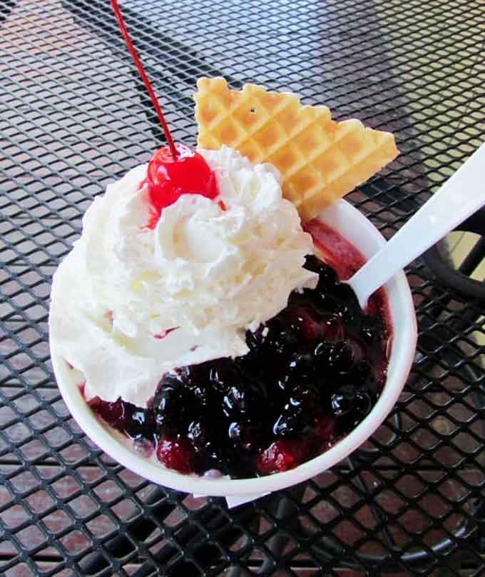Mixed berry sundae topped with whipped cream and a waffle cookie, because sometimes life hands you exactly what you need.