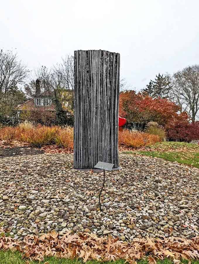 Vertical rhythms echo in this textured column, its surface catching light like a prehistoric tree trunk fossilized in metal.