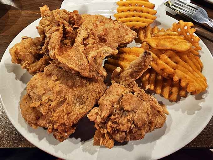 That pile of perfectly fried chicken with waffle fries is basically a love letter to anyone who appreciates food done right.