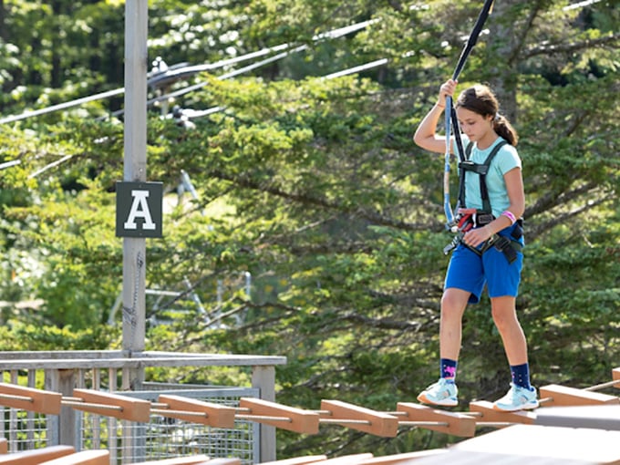 Safety first! Young adventurers get properly harnessed before tackling the course's many obstacles and zip lines.