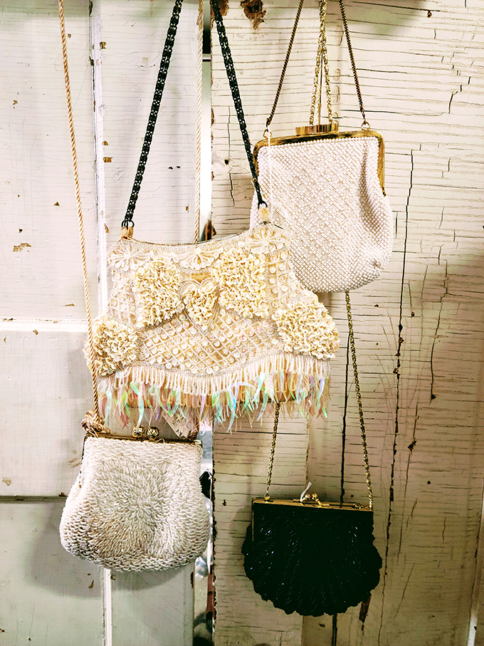 Vintage beaded purses hang like jewelry themselves, their intricate patterns and delicate clasps showcasing craftsmanship rarely seen in today's accessories.