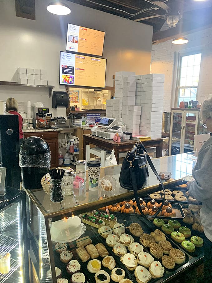 At the counter, stacks of pizza boxes stand ready for takeout orders, while the display case below showcases cookies that practically beg to jump into your shopping bag.