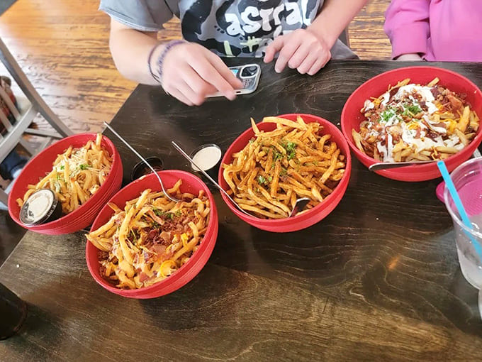 A French fry festival in vibrant red bowls &ndash; each variation offering its own unique flavor journey from classic to adventurous.