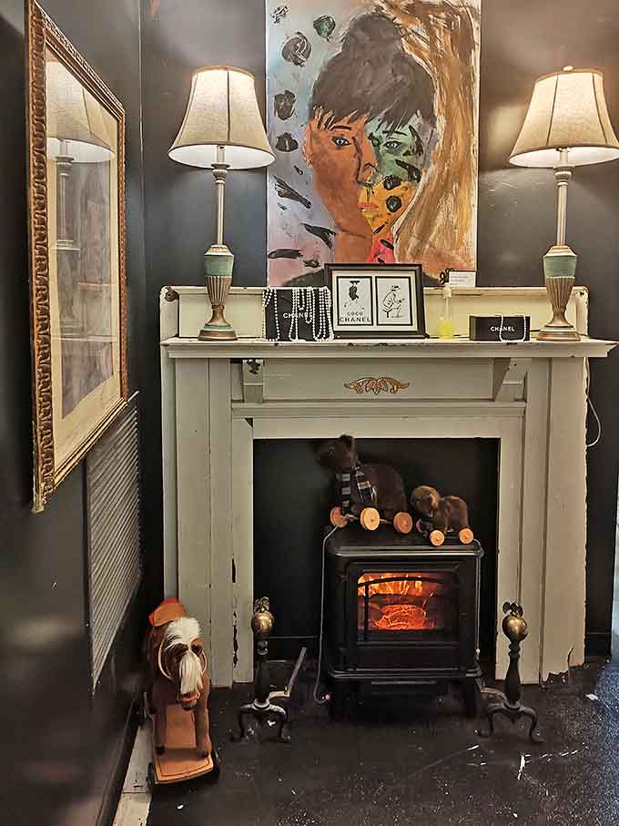 Cozy sophistication emanates from this charcoal-walled nook where art meets ambiance beside a vintage fireplace and elegant lamps.