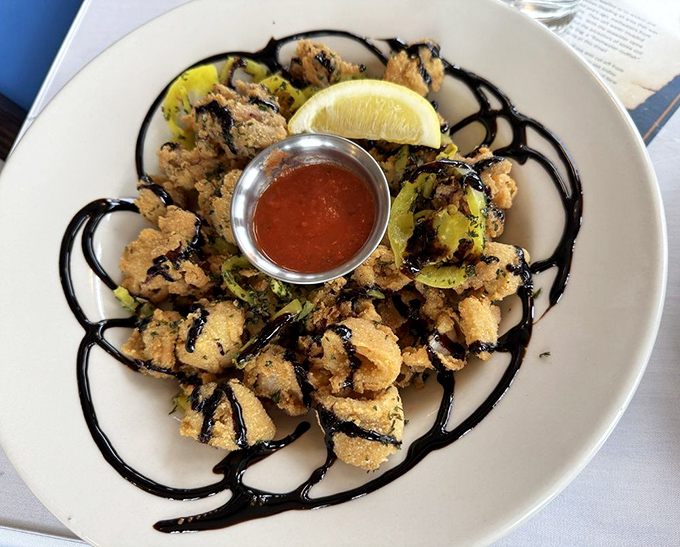 Crispy calamari arranged like a delicate flower, the tentacles and rings fried to golden perfection and drizzled with balsamic reduction for that extra flavor punch.
