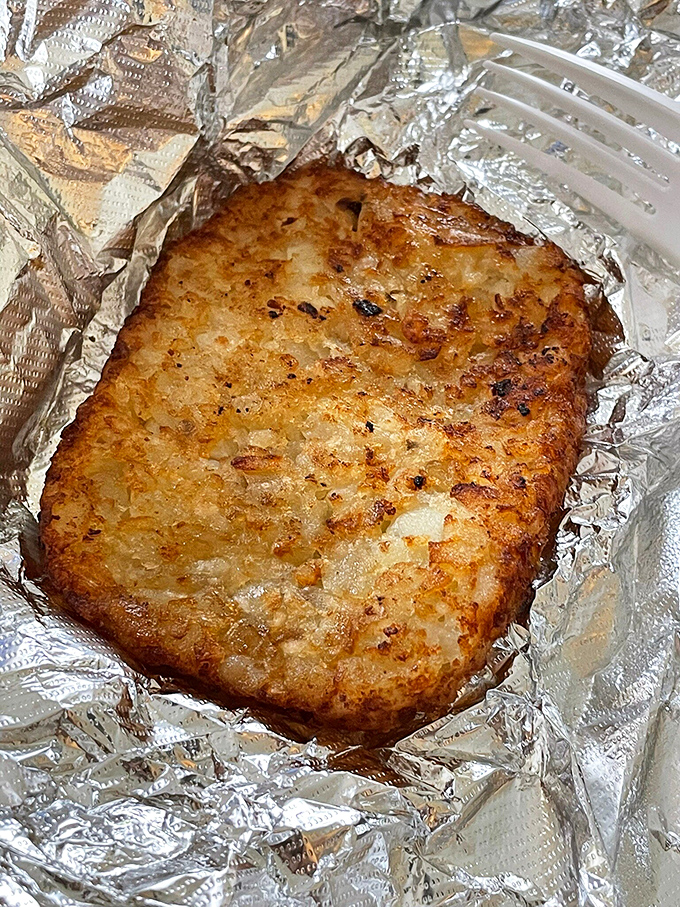 Golden-brown hash brown perfection &ndash; crispy exterior giving way to tender potato inside, like a little breakfast treasure wrapped in foil.