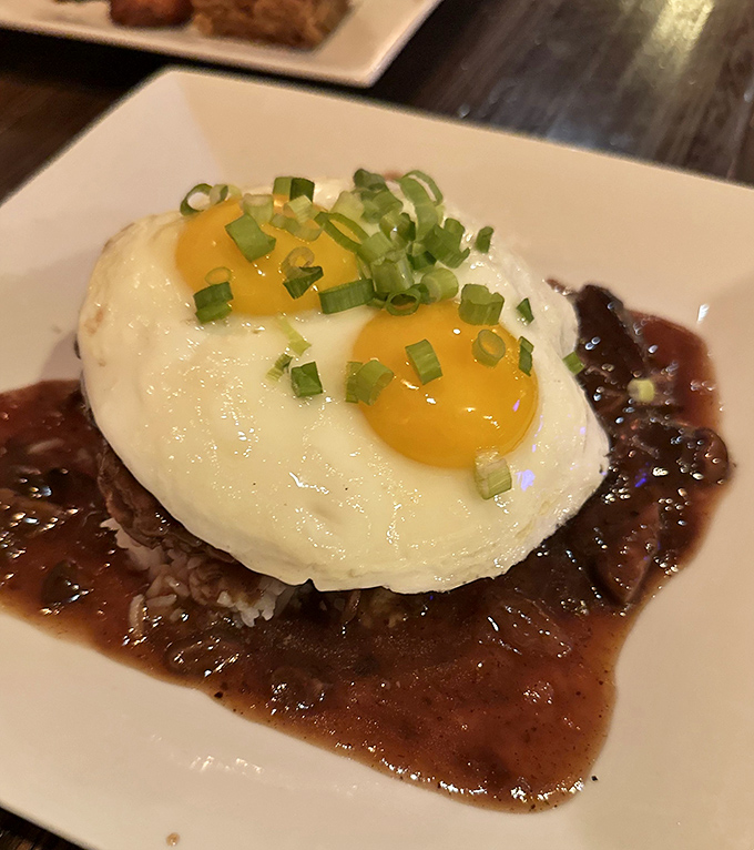 Hula's Loco Moco transforms a humble hamburger patty with two sunny eggs and rich gravy &ndash; breakfast meets dinner in Hawaiian comfort food perfection.