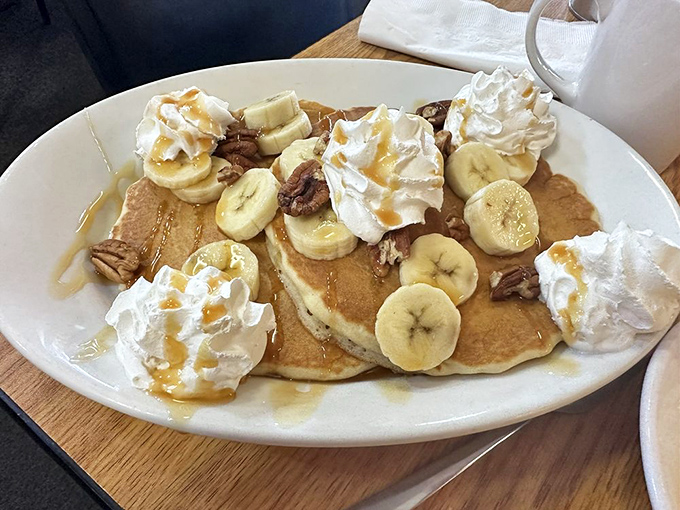 Pancake heaven! Golden discs topped with bananas, whipped cream, and pecans &ndash; breakfast that borders deliciously on dessert territory.