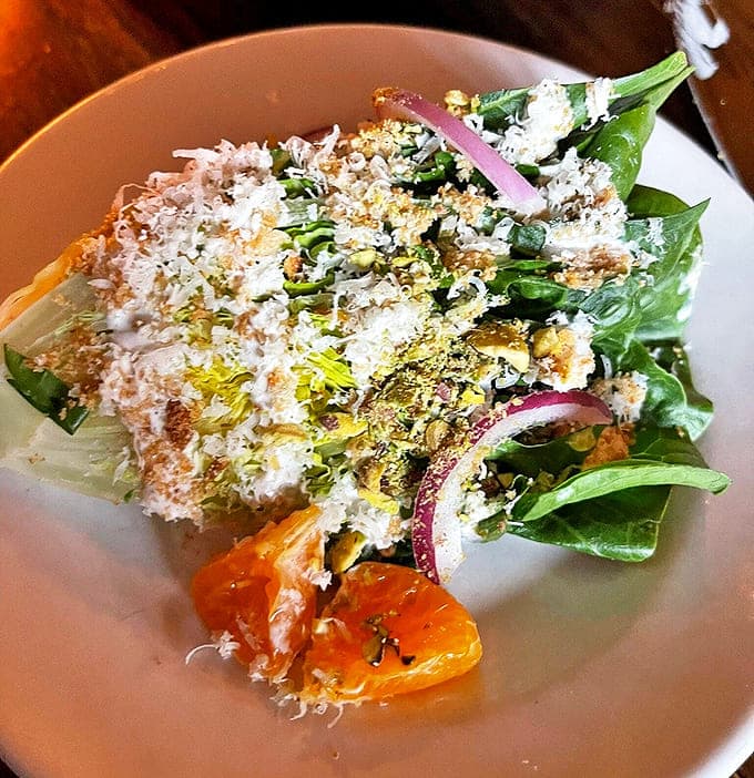 Looking for something light? Our crisp wedge salad features fresh citrus, crunchy pistachios, and a dusting of savory cheese.