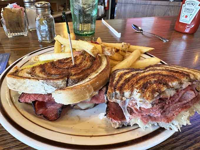 The towering Reuben sandwich on grilled rye requires a strategic eating plan but delivers classic deli flavors in every messy bite.