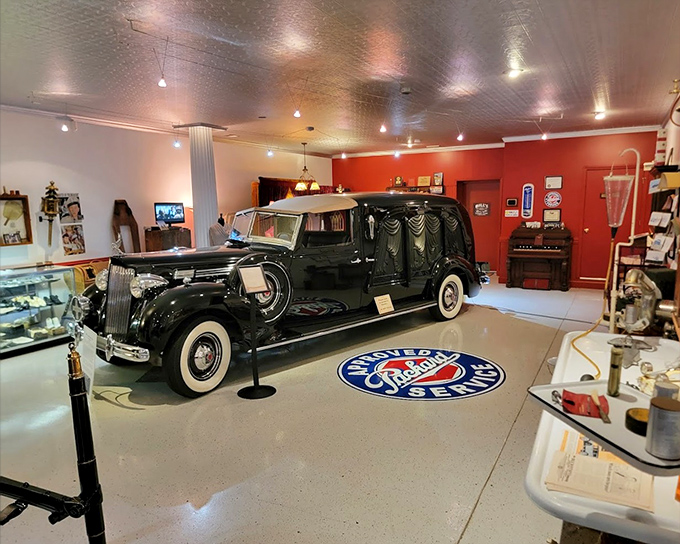 Inside the Mortuary Museum, a pristine vintage hearse takes center stage, its gleaming black finish and elegant details showcasing the craftsmanship of funeral vehicles from a bygone era.