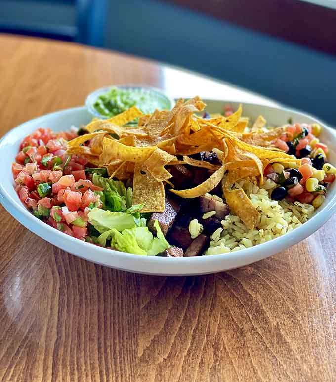 This loaded burrito bowl packs rice, beans, fresh veggies, and crispy tortilla strips into one colorful, satisfying meal.