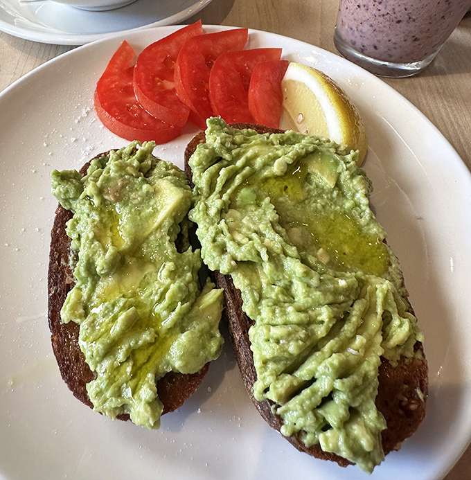 Avocado toast elevated beyond basic status &ndash; creamy green goodness on hearty bread with a squeeze of lemon that brightens everything.