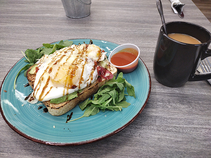 Avocado toast elevated beyond basic status with perfectly poached eggs, arugula, and a drizzle of something magical that ties it all together.