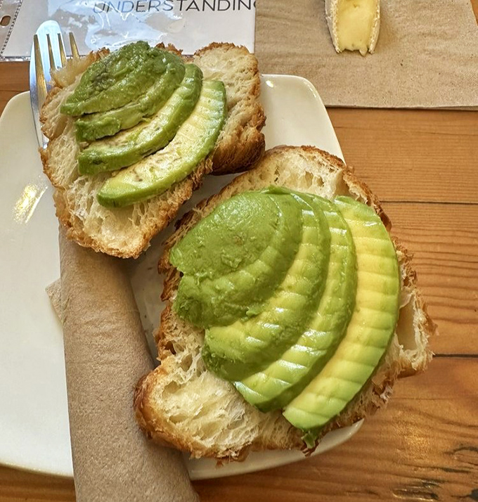 Avocado toast elevated from millennial clich&eacute; to culinary masterpiece with perfectly ripe fruit and artful presentation.