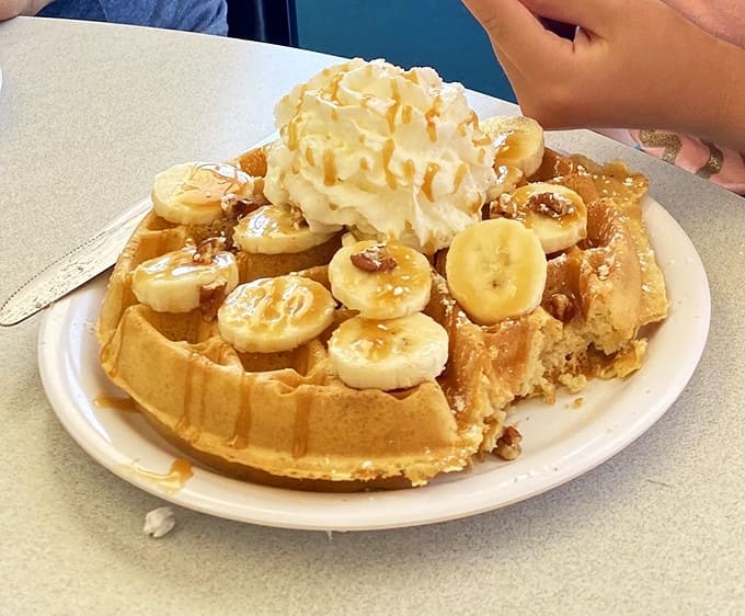The Bananas Foster Waffle transforms breakfast into dessert - caramelized bananas and whipped cream creating a morning carnival for your taste buds.