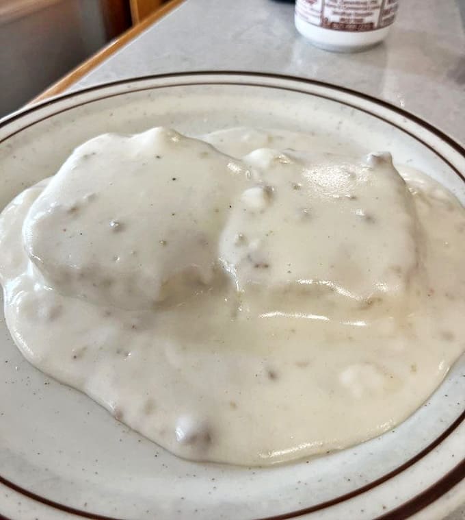 Biscuits drowning happily in creamy sausage gravy &ndash; the breakfast equivalent of a warm hug on a cold Illinois morning.