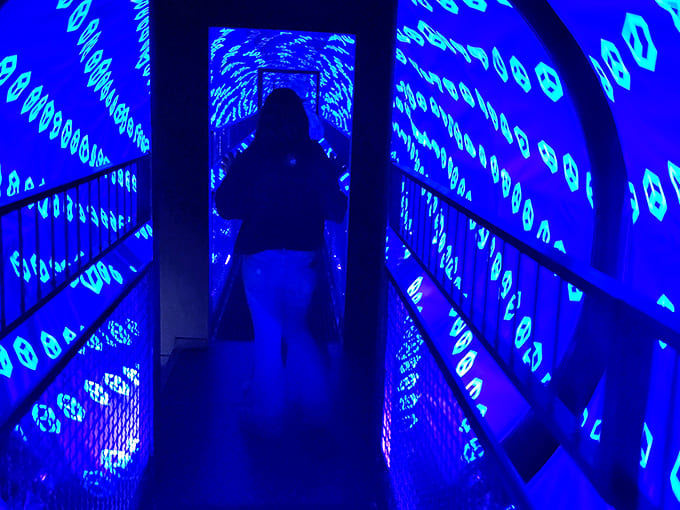 The infinity tunnel creates a dizzying path of endless blue symbols that seem to stretch into another dimension entirely.