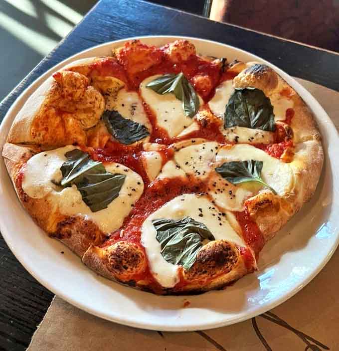 Pizza purists, rejoice! This Margherita showcases the beauty of simplicity with its blistered crust, San Marzano tomatoes, and fresh basil leaves.