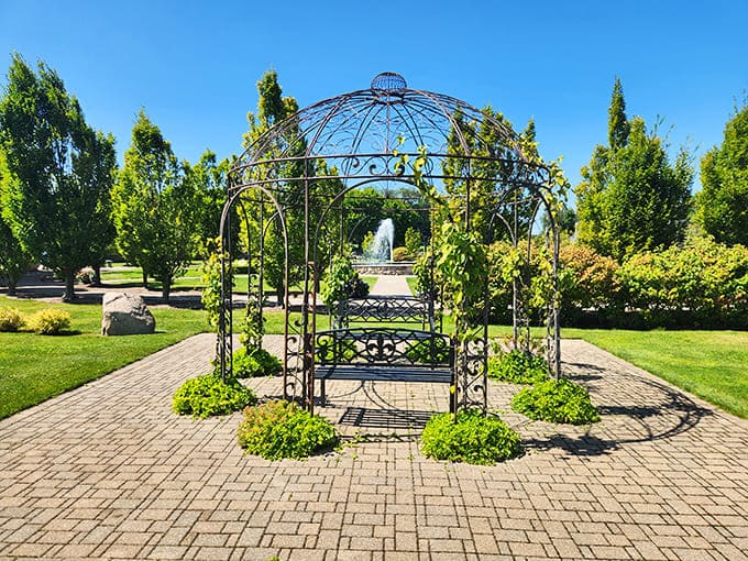 A peaceful gazebo reflects in still waters, offering a quiet moment away from the castle's grandeur where visitors can simply breathe and be.