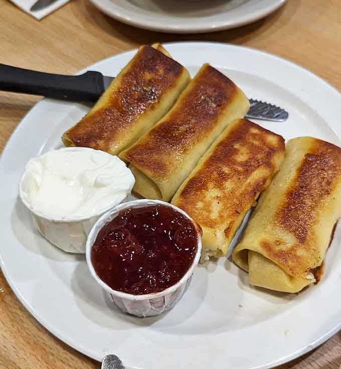These blintzes are delicate crepe perfection, rolled tight and served with sour cream and jam for a sweet, satisfying finish.