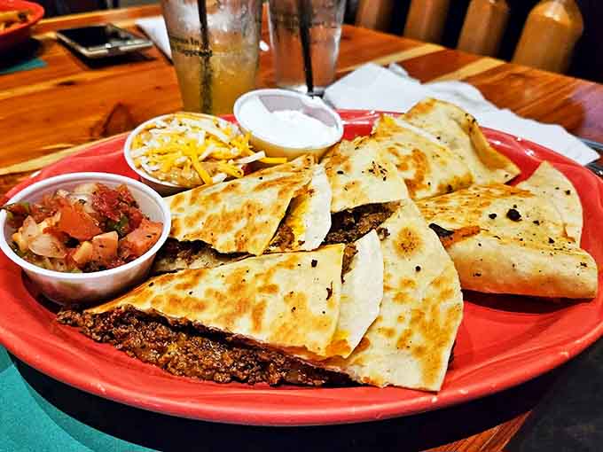 Quesadillas arrive piping hot, their crisp tortillas giving way to savory fillings, accompanied by fresh salsa and sour cream for the perfect bite.