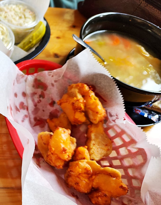 The perfect Wisconsin pairing! Golden cheese curds nestled in their paper basket alongside a steaming bowl of homestyle soup &ndash; comfort food that warms both body and soul.