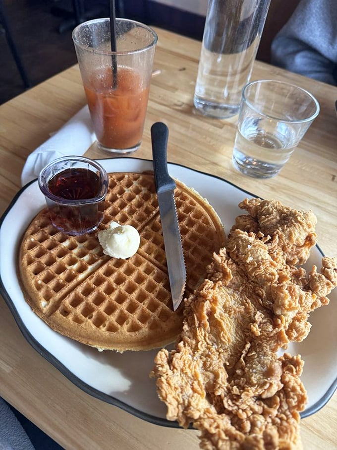 The ultimate sweet-savory harmony: crispy fried chicken meets fluffy buttermilk waffle, waiting for that maple syrup drizzle.
