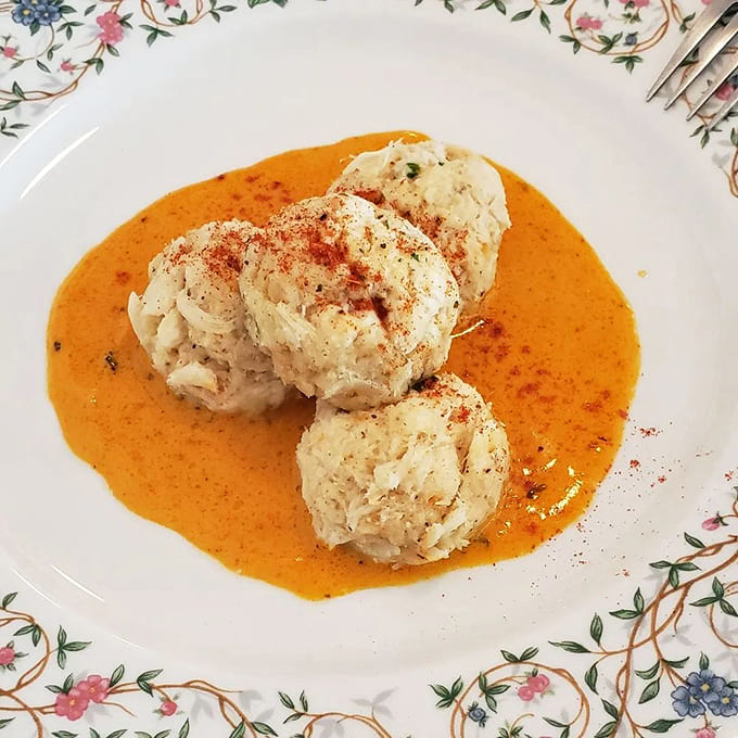 These crab cakes sit in their golden sauce like treasure waiting to be discovered, proving that good things really do come to those who order wisely.