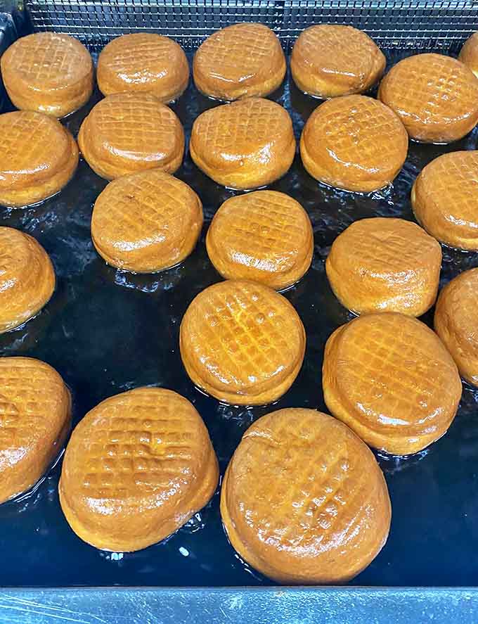 These deep-fried glazed donuts glisten with sweet perfection, promising that ideal combination of crisp exterior and pillowy interior.