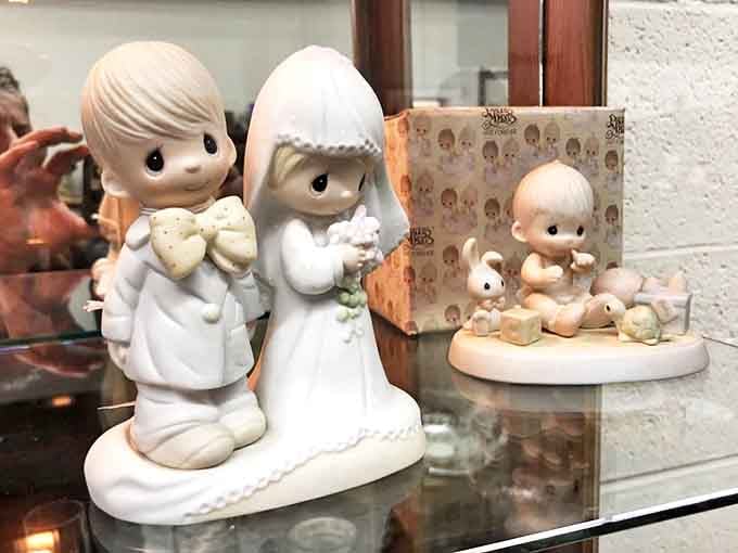 Precious Moments figurines keeping watch over the merchandise like tiny porcelain security guards protecting your next nostalgic purchase.