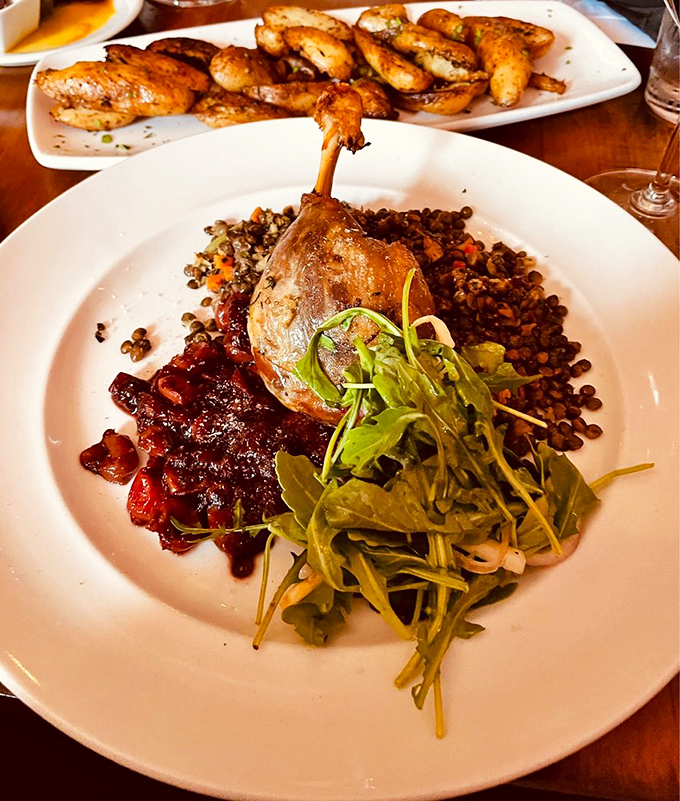 This duck confit is ready for its close-up! Perched atop a colorful medley of lentils and greens, it's the poultry equivalent of a Hollywood star on the red carpet.