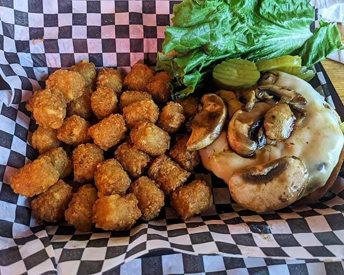 The mushroom Swiss burger with tater tots represents comfort food at its finest, no apologies necessary for the indulgence.