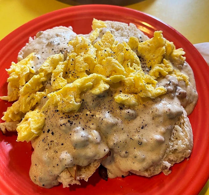 Scrambled eggs cascading over biscuits and gravy like a delicious avalanche, proving that sometimes more really is more, especially before noon.