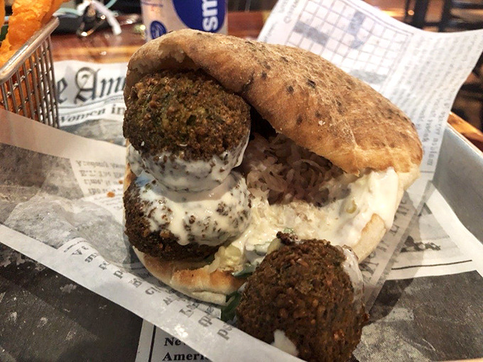 Golden-brown falafel tucked into pillowy pita alongside crispy sweet potato fries &ndash; comfort food that somehow feels virtuous and indulgent simultaneously.